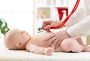 A doctor checking a baby's heartbeat